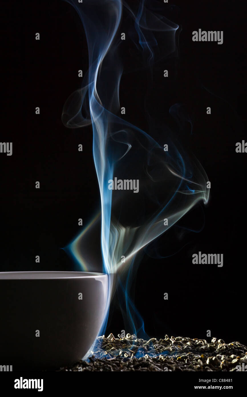 Smoke and cup with grain of tea Stock Photo - Alamy