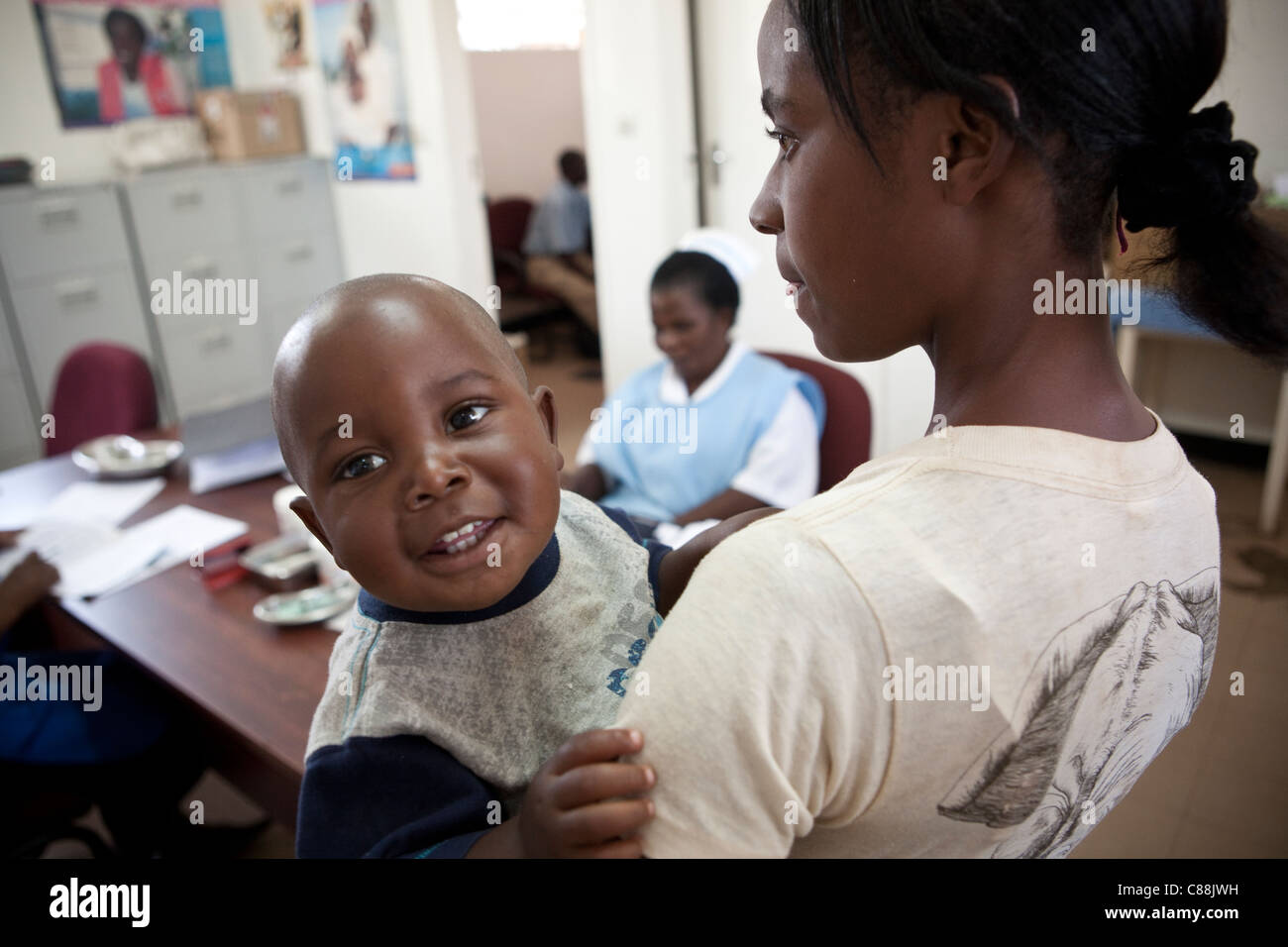 A mother brings her young child to an AIDS Relief clinic supported by ...