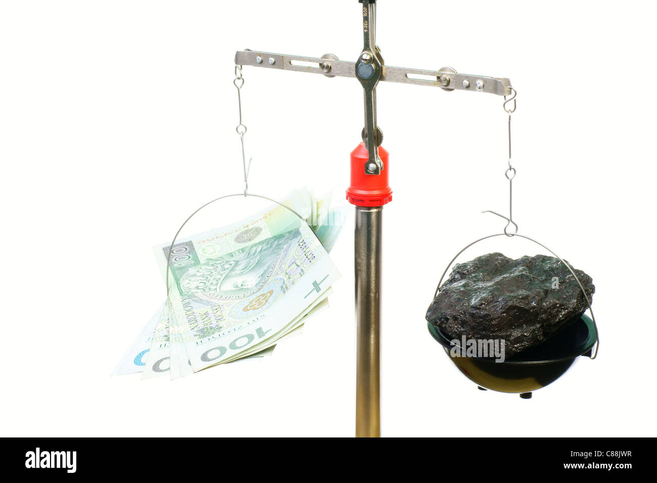 scale pan with money and coal Stock Photo - Alamy
