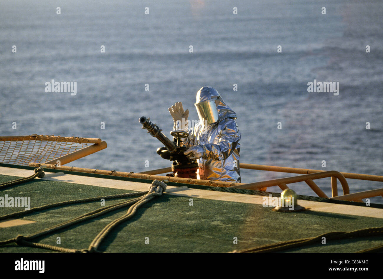 Rio de Janeiro, Brazil. Oil rig worker in silver fireproof suit and ...