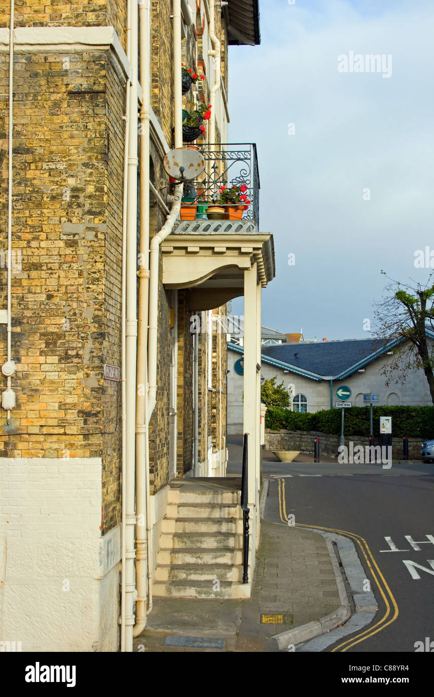 First floor balcony with flower pots above front door steps as seen ...