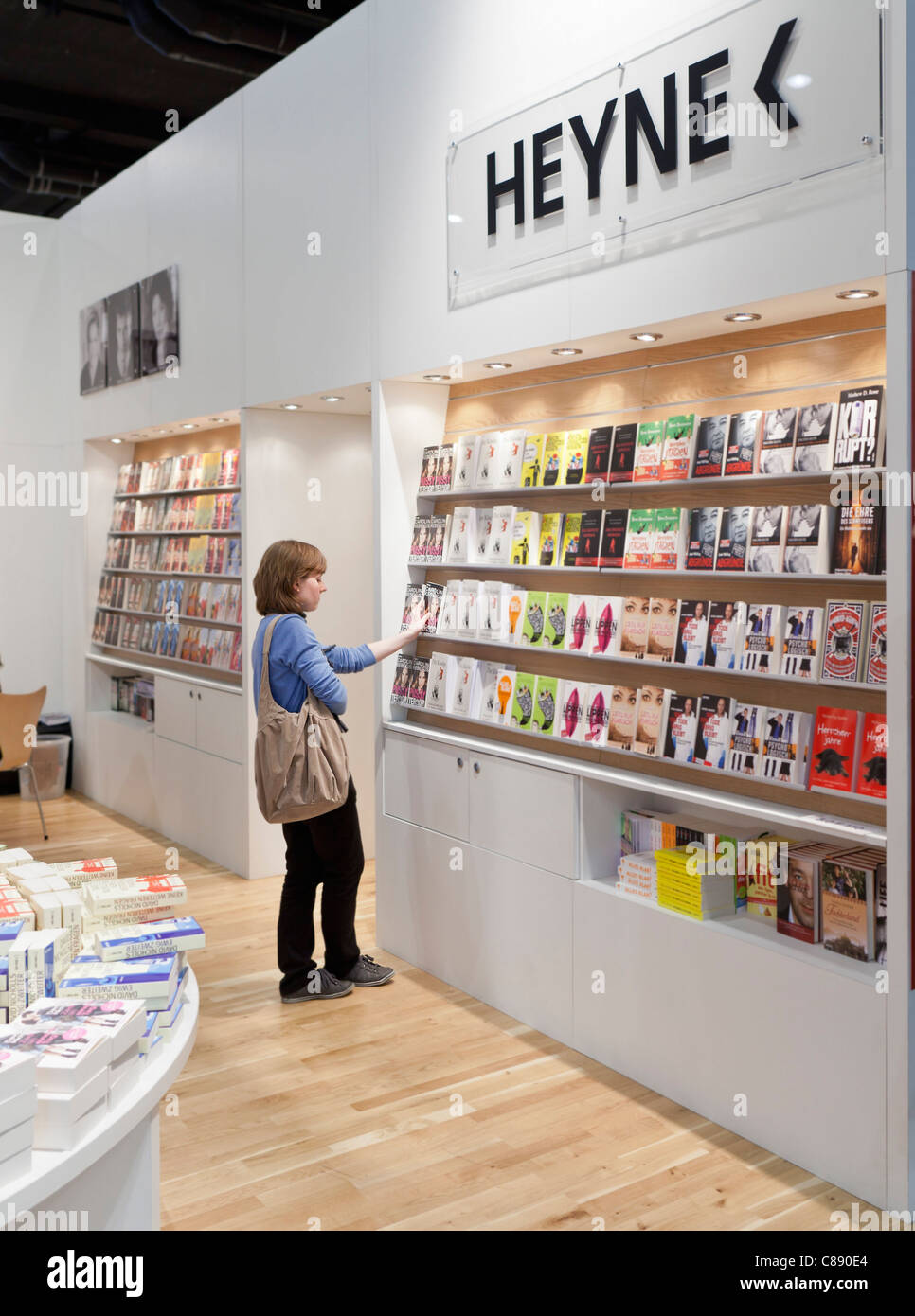 Visitor reading book at the Heyne publisher booth at the international ...