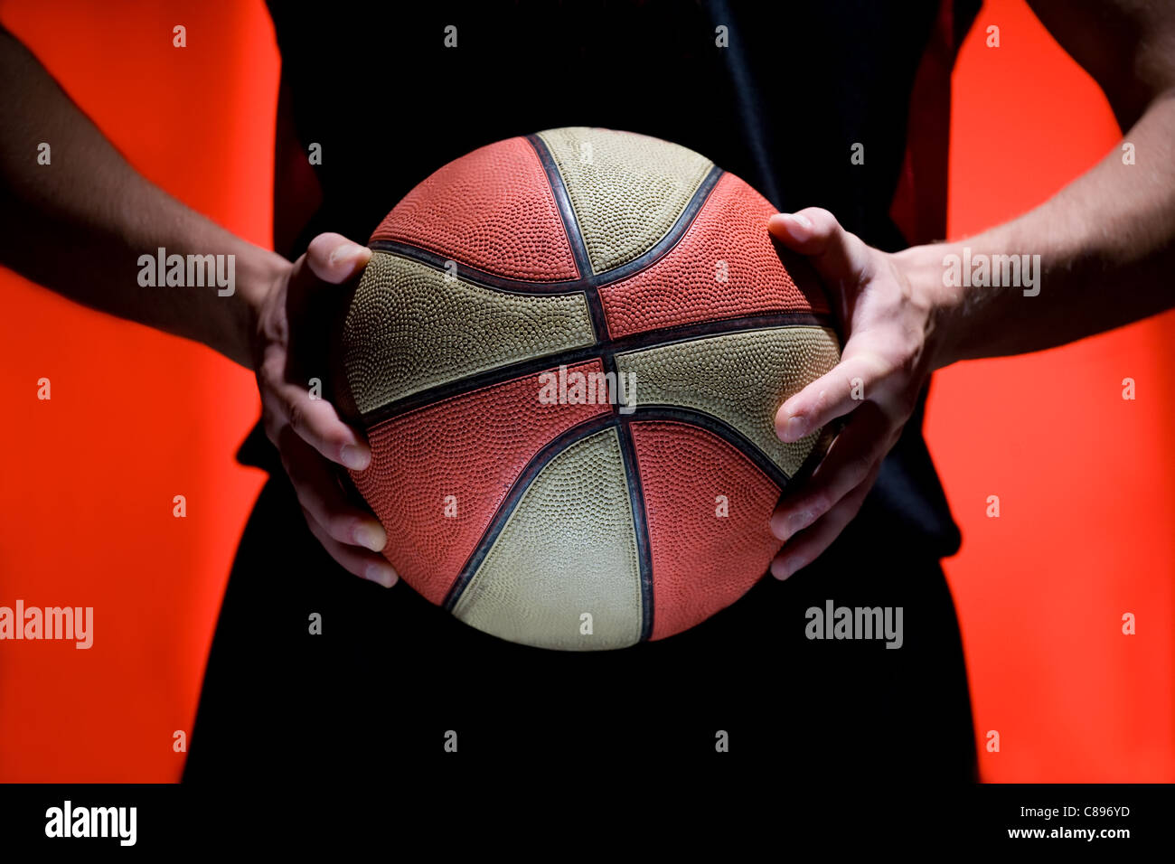 Basketball ball in hands of player isolated red background Stock Photo ...
