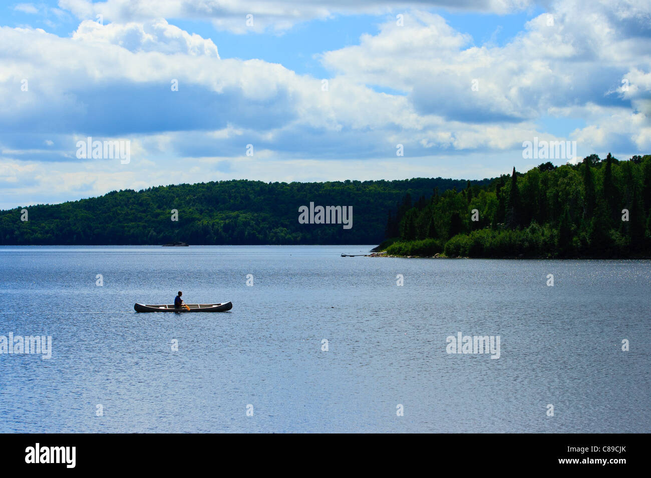 Canoeist Paddles on a Calm Wilderness Lake Stock Photo - Alamy