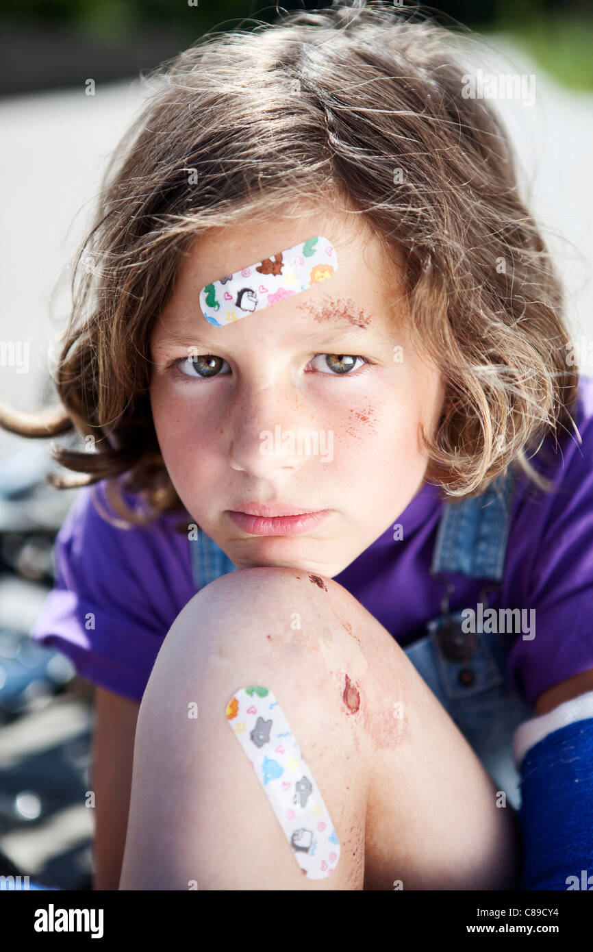 Germany, Bavaria, Wounded girl sitting on road after bicycle accident ...