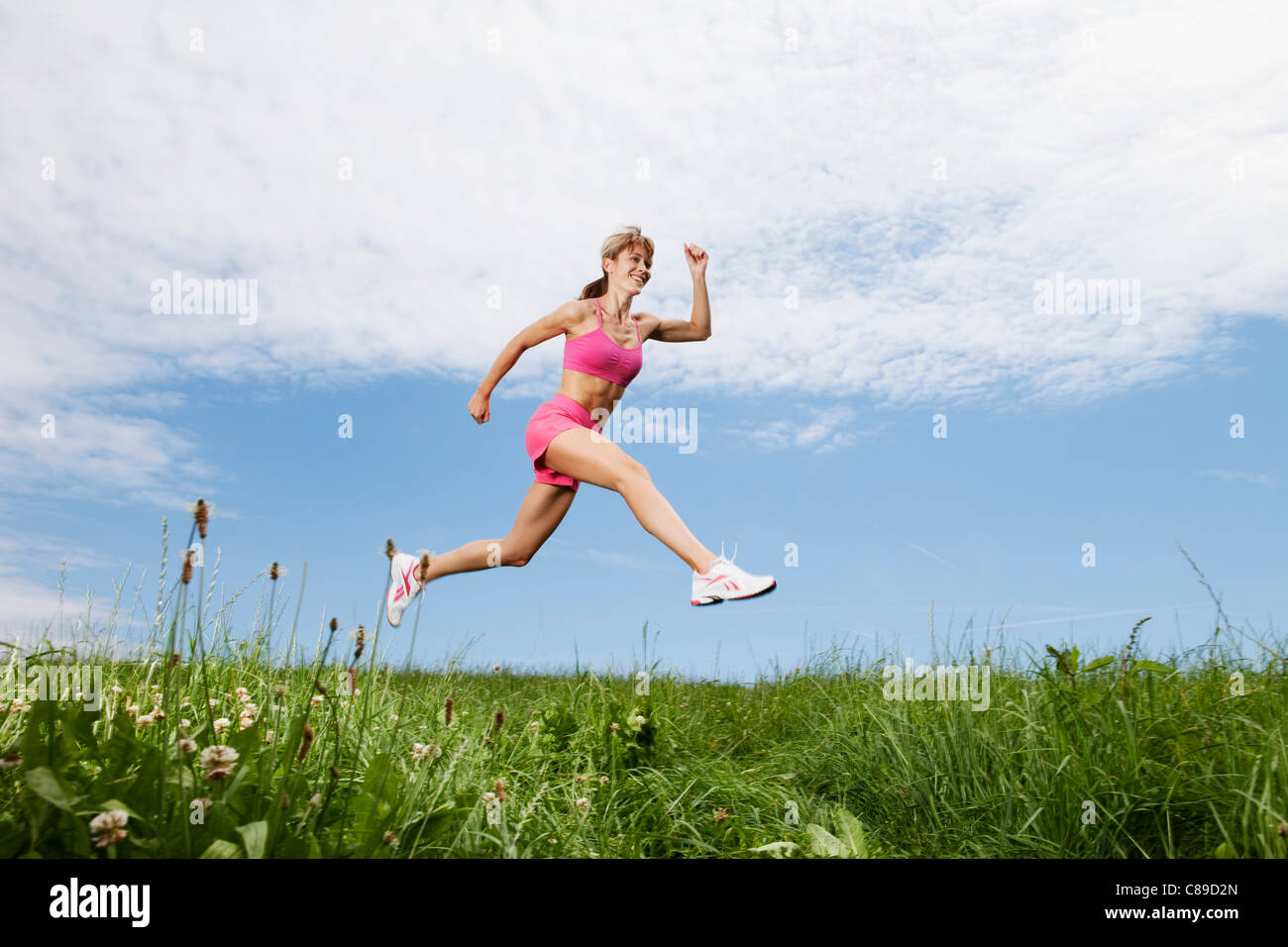 Woman running on grass trainers hi-res stock photography and images - Alamy