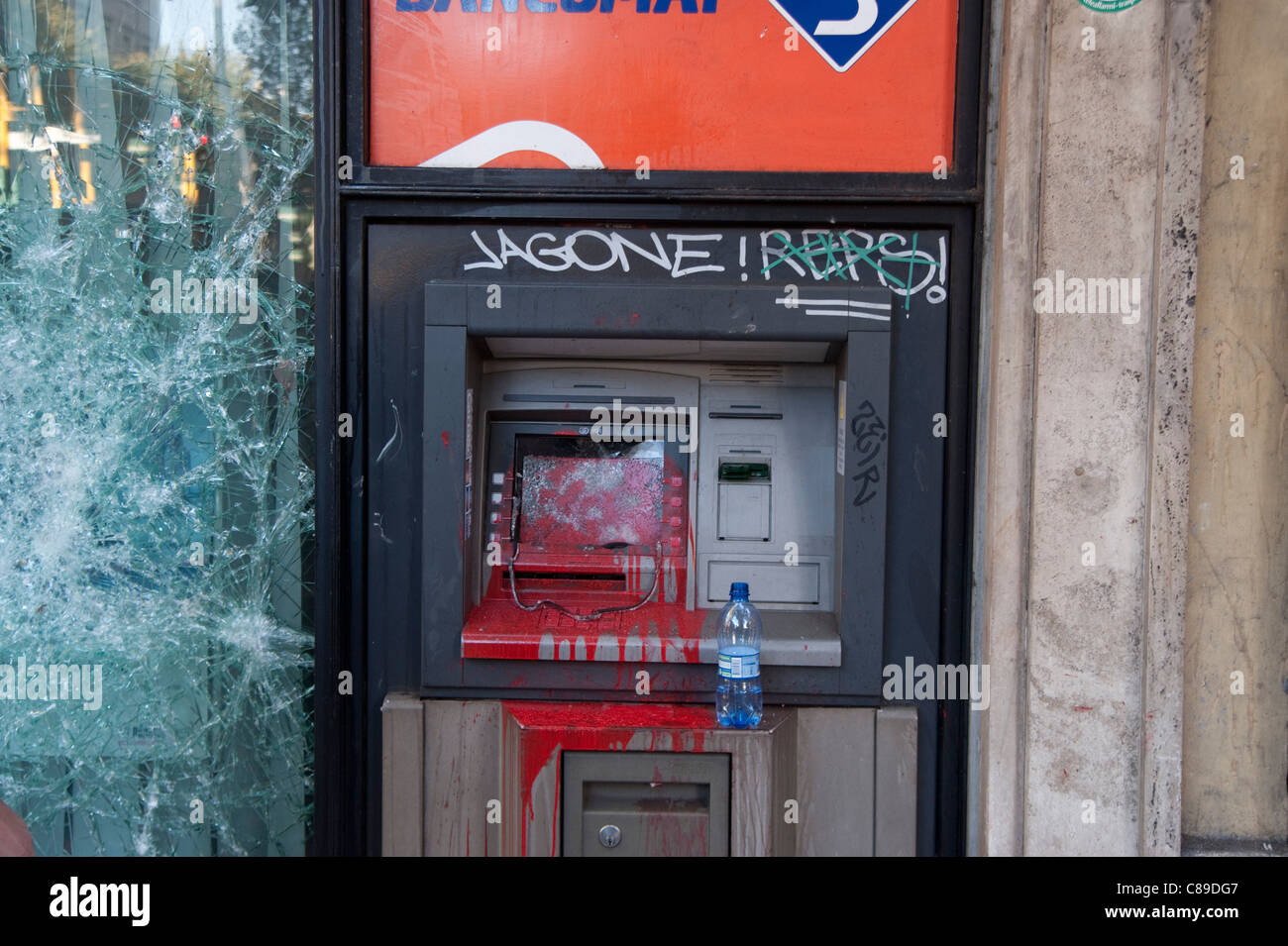 A broken cash machine of a Bank and anti government sign are seen ...
