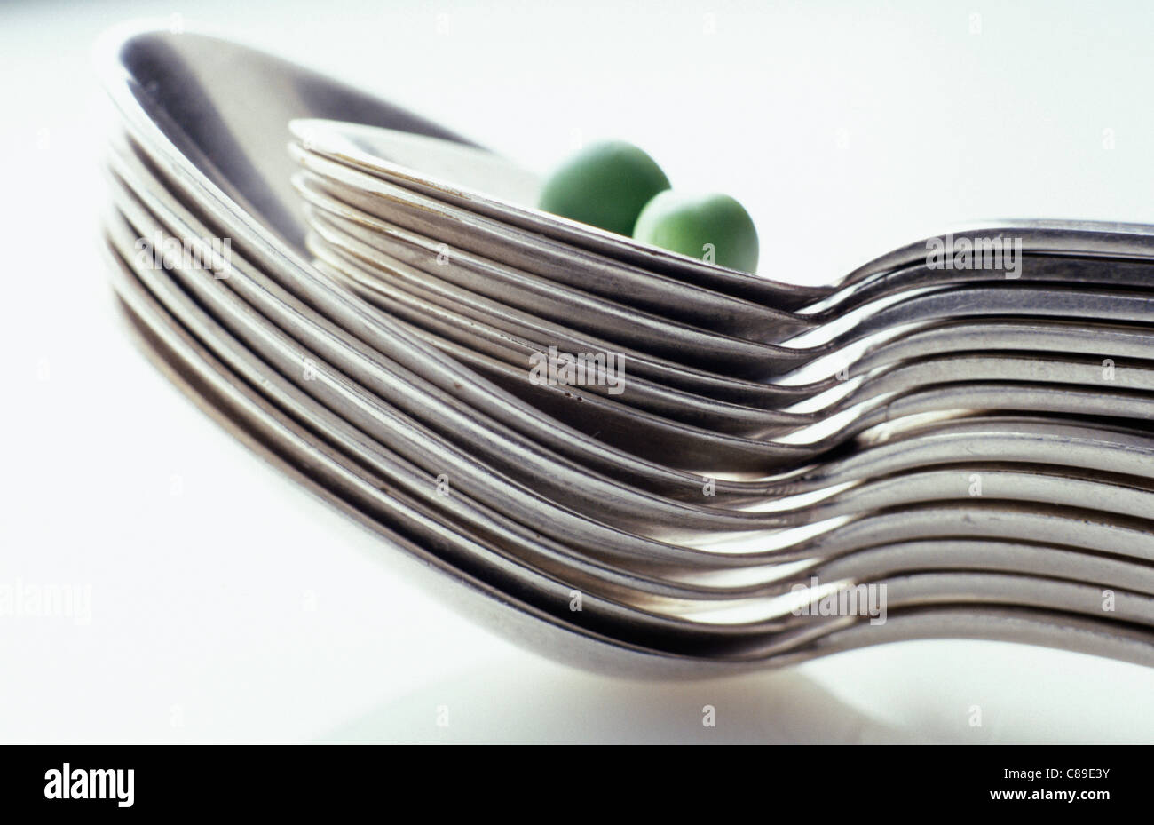 Pile of spoons with a pea on the top Stock Photo - Alamy