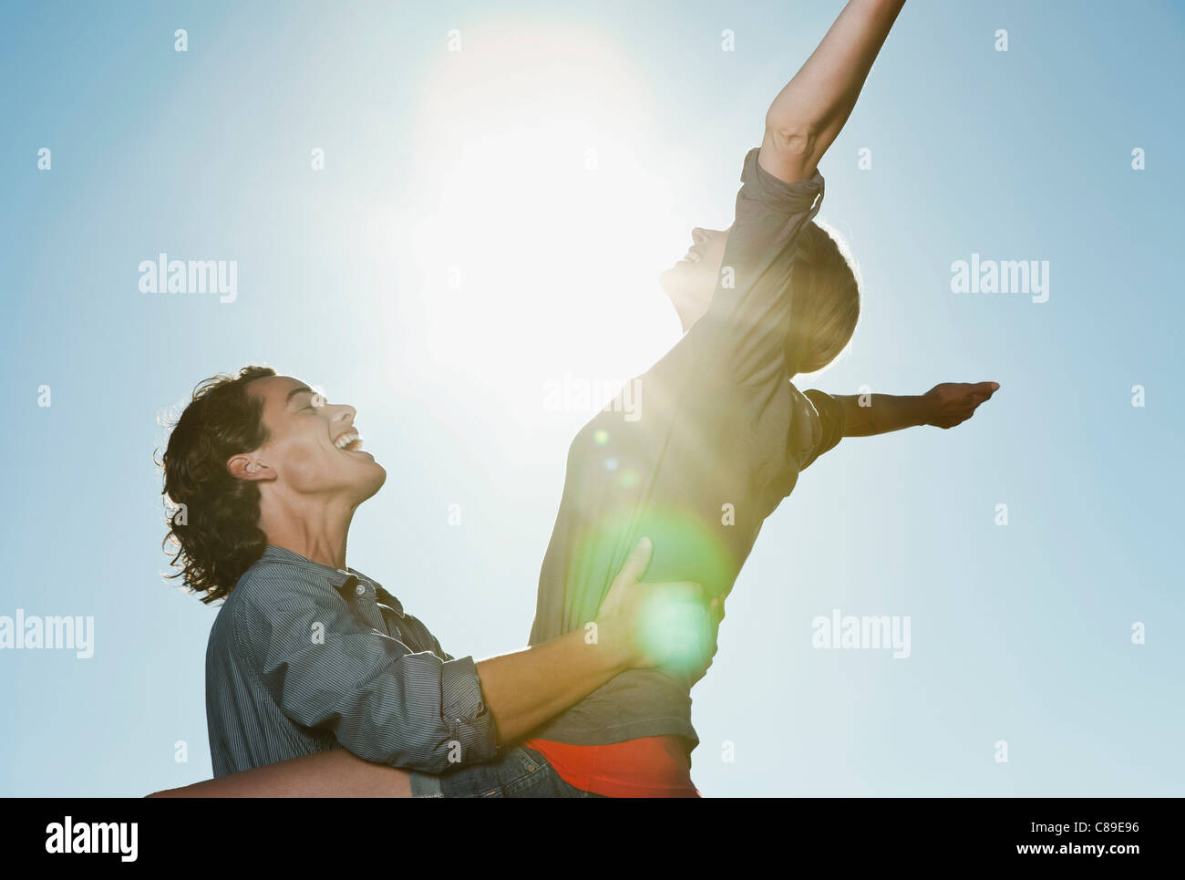 Italy, Tuscany, Young man carrying woman against sun Stock Photo - Alamy