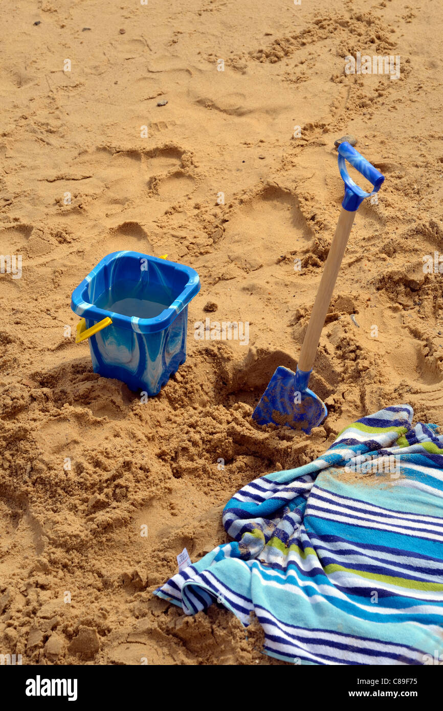 bucket and spade and towel on sandy beach Stock Photo - Alamy