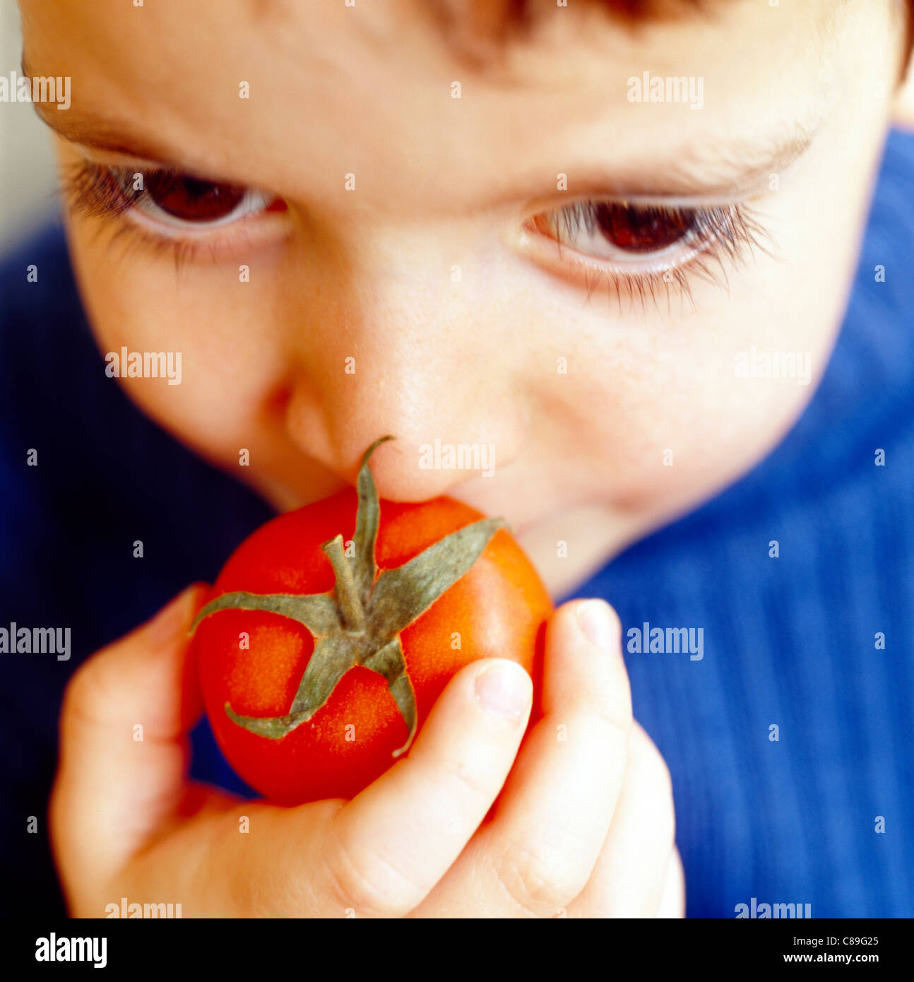 Child smelling a tomato Stock Photo - Alamy