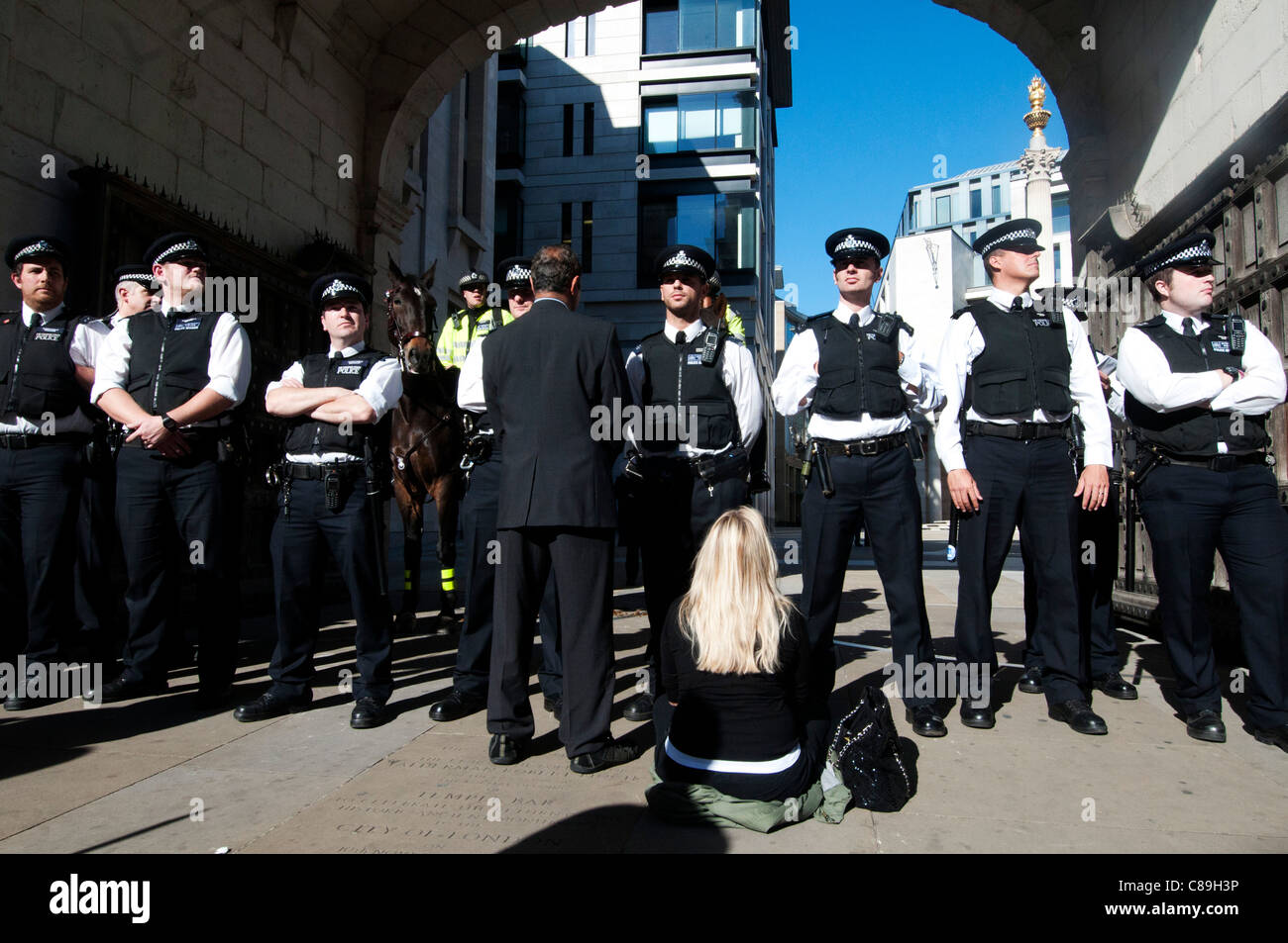 Occupy London.A man and woman confront a line of police stopping people ...