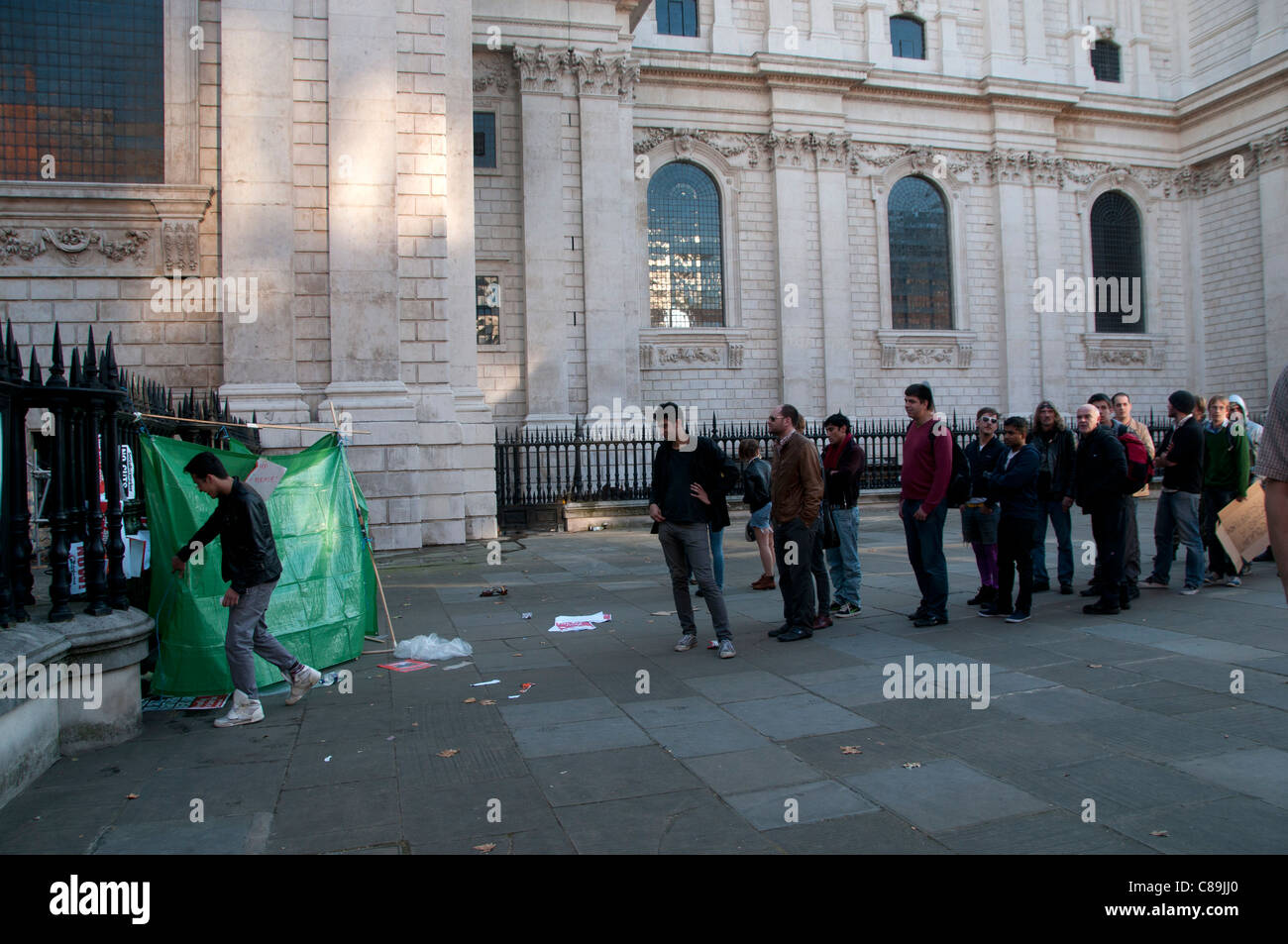 Occupy London. A line of men queue for a make-shift toilet in front of ...