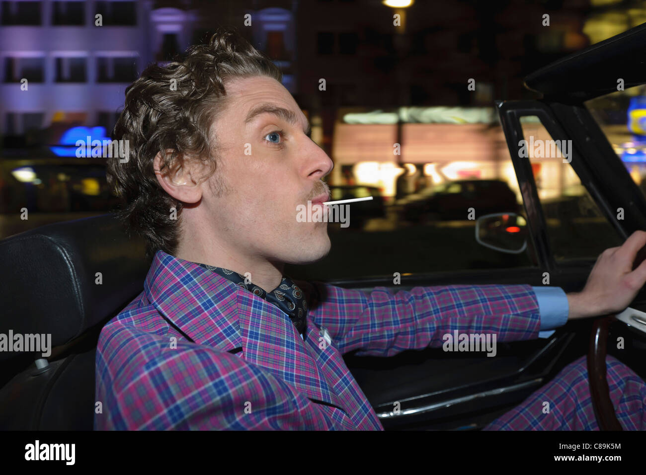 Germany, Hamburg, Man driving classic cabriolet car at night Stock ...