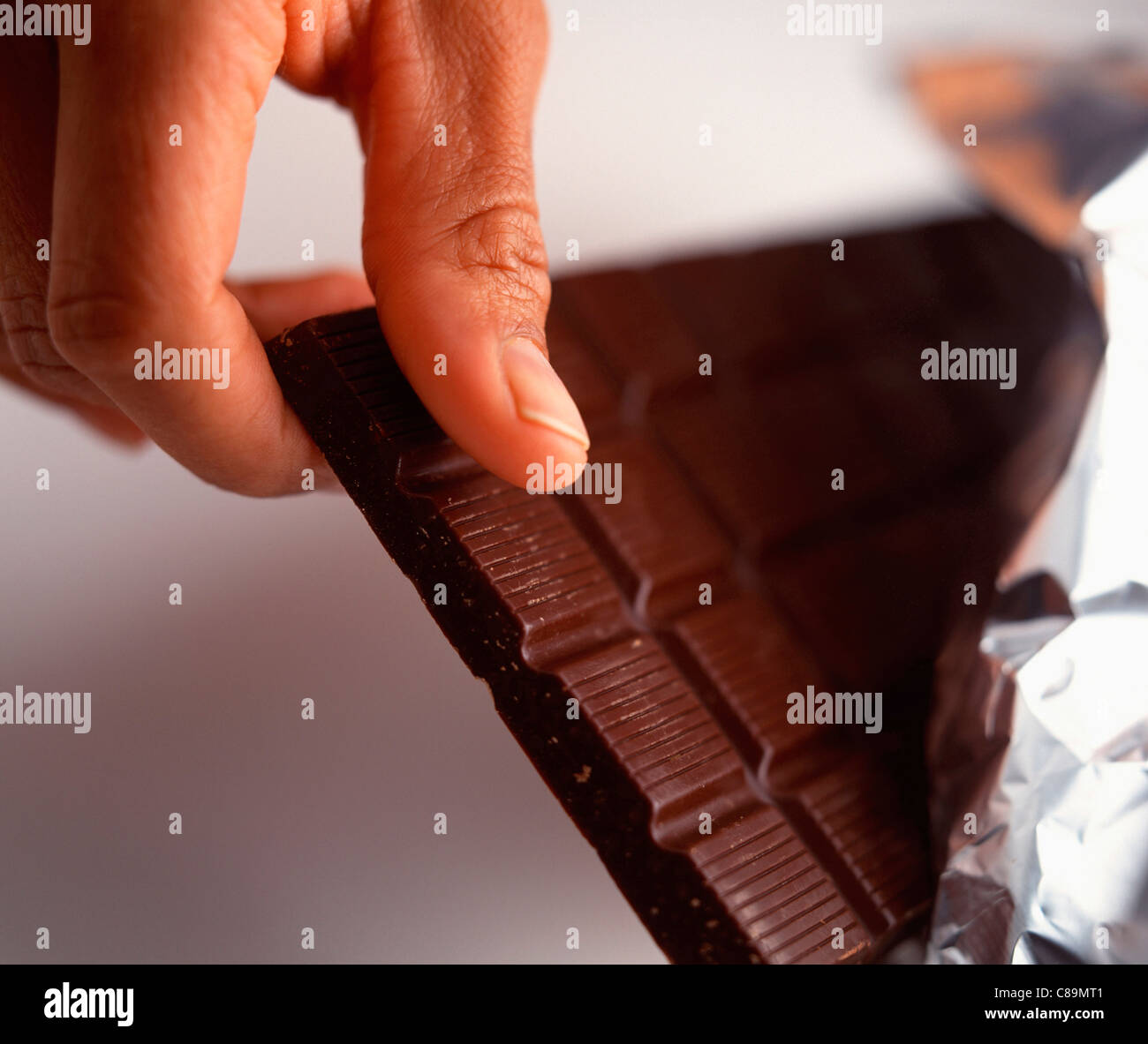 Bar of plain chocolate and hand Stock Photo - Alamy