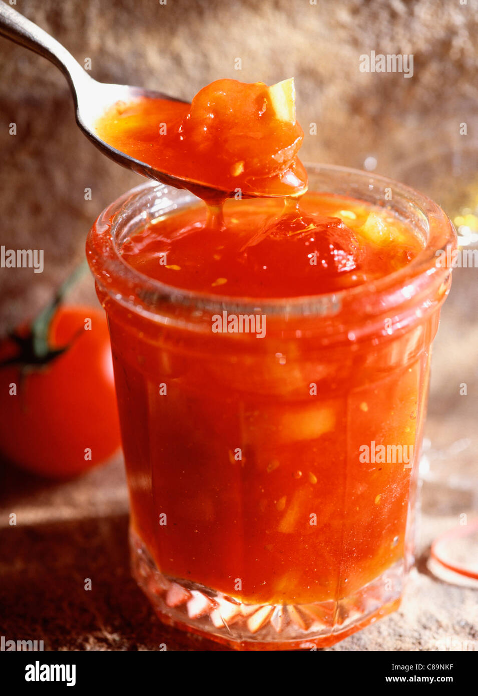 Pot of tomato jam with spoon Stock Photo - Alamy