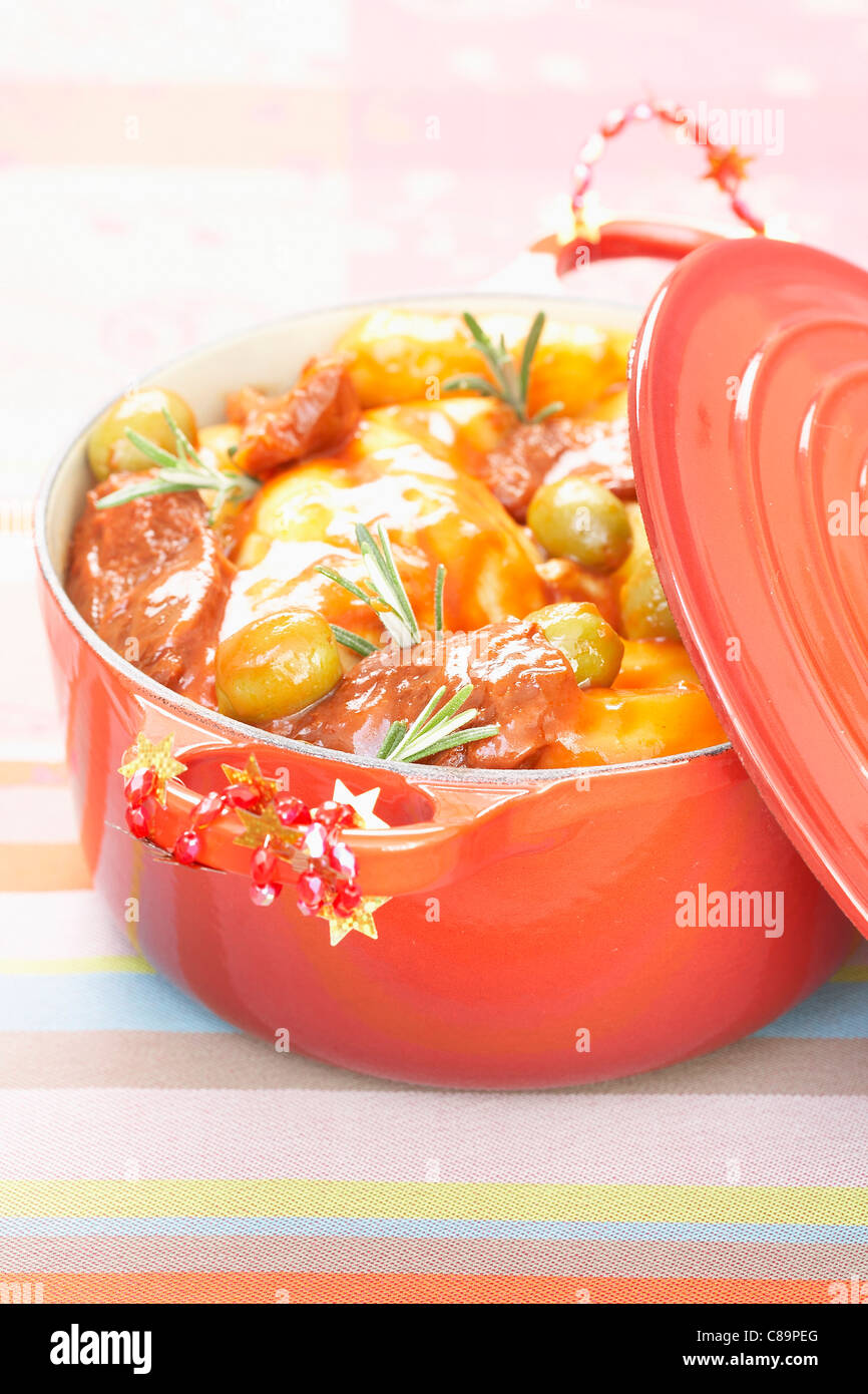 Casserole dish of rabbit legs with tomato sauce and green olives Stock ...