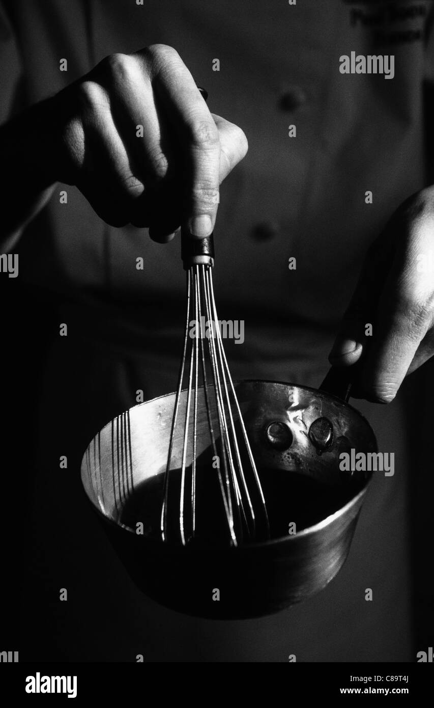 Mixing a sauce with a whisk in a saucepan Stock Photo - Alamy