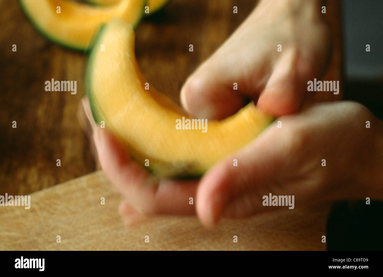 Taking the the skin off the melon Stock Photo - Alamy