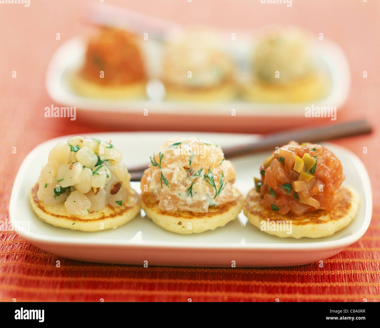 Assorted tartares on mini blinis Stock Photo - Alamy