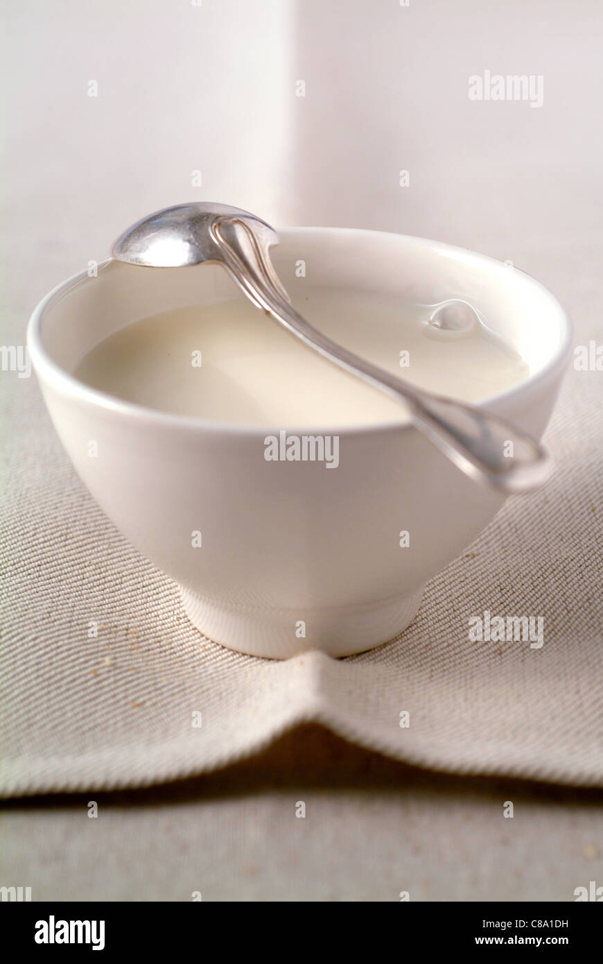Bowl of milk with spoon Stock Photo - Alamy