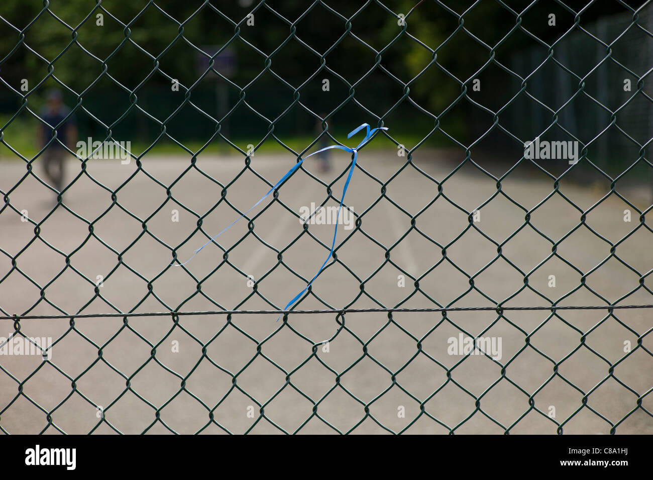Blue ribbon tied onto fencing around tennis courts in park Stock Photo ...