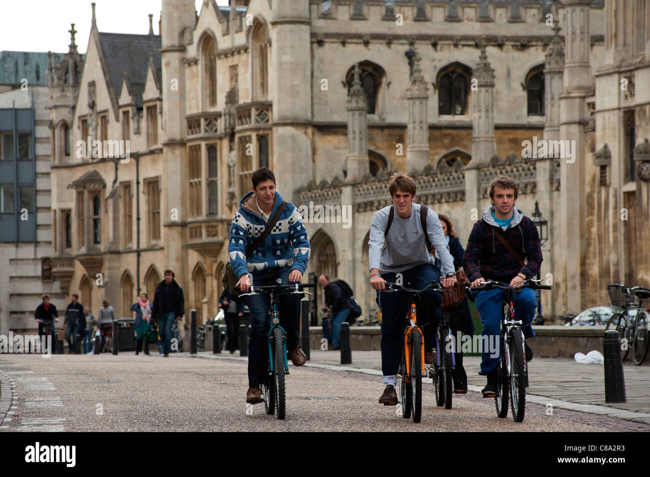Cambridge University, England. Students cycle past Kings College autumn ...