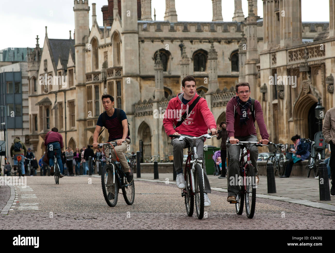 Cambridge University, England. Students cycle past Kings College autumn ...