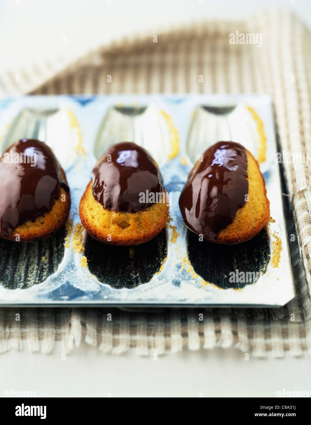 Madeleines coated with melted chocolate Stock Photo - Alamy