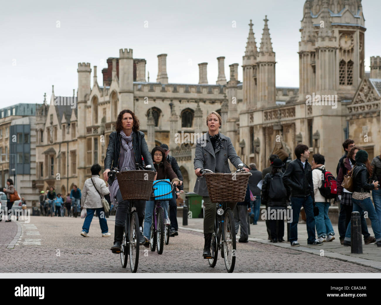 Cambridge University, England. Students cycle past Kings College autumn ...