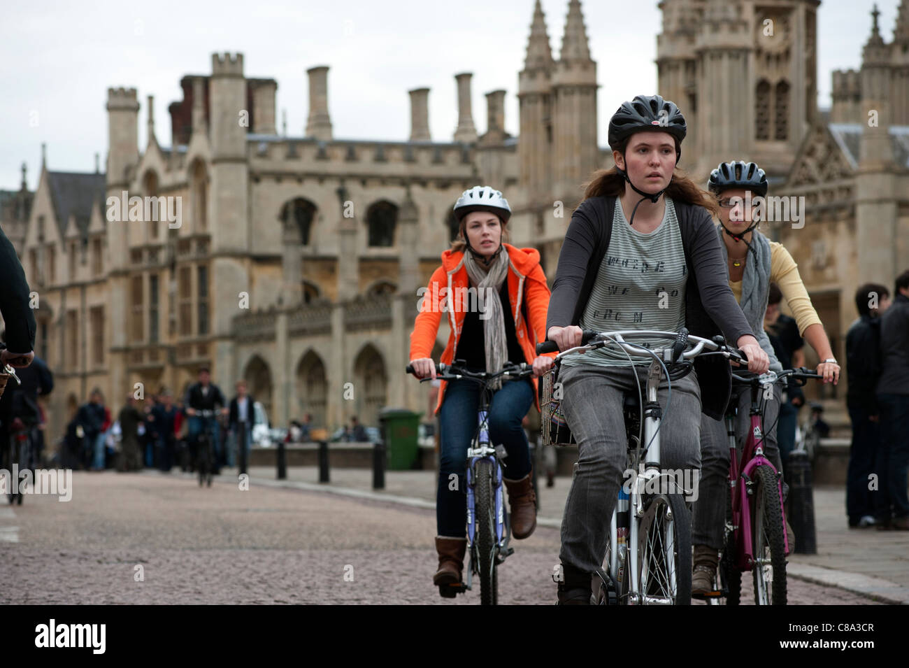 Cambridge University, England. Students cycle past Kings College autumn ...