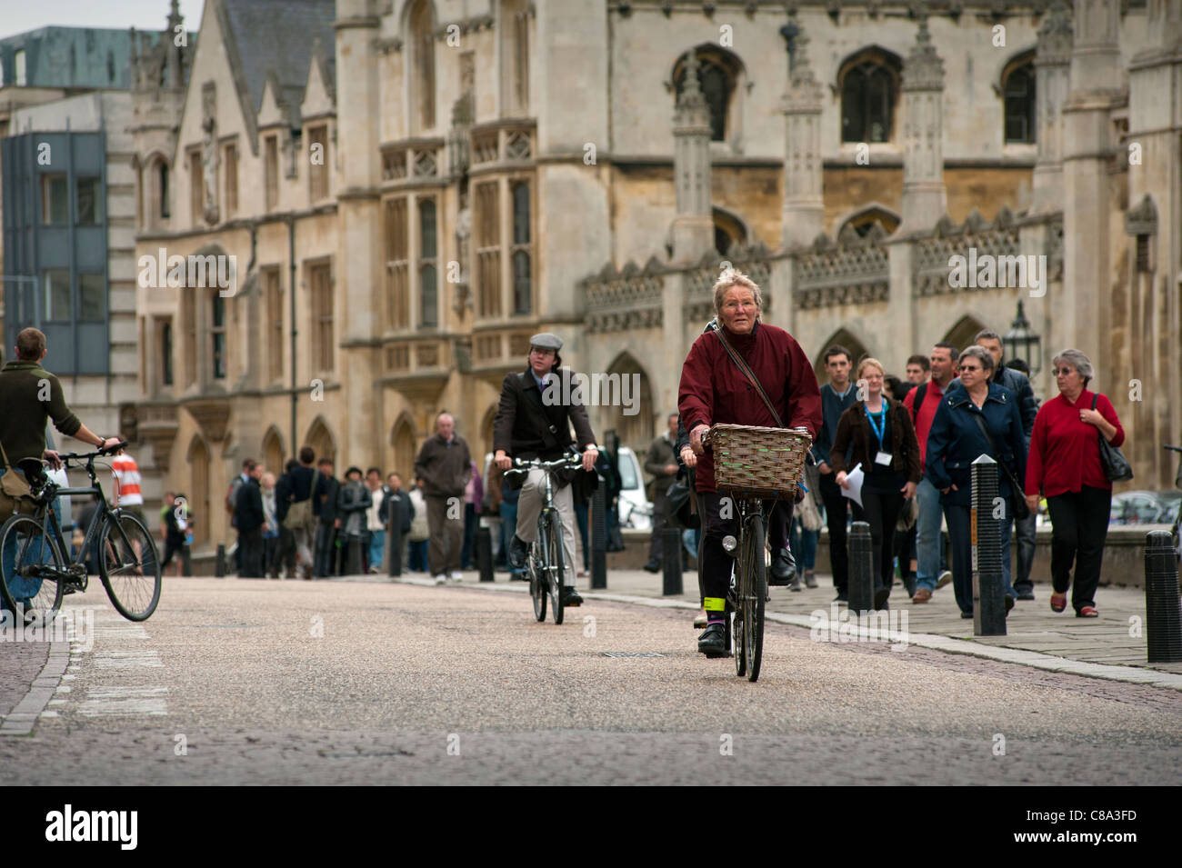 Cambridge University, England. Students cycle past Kings College autumn ...