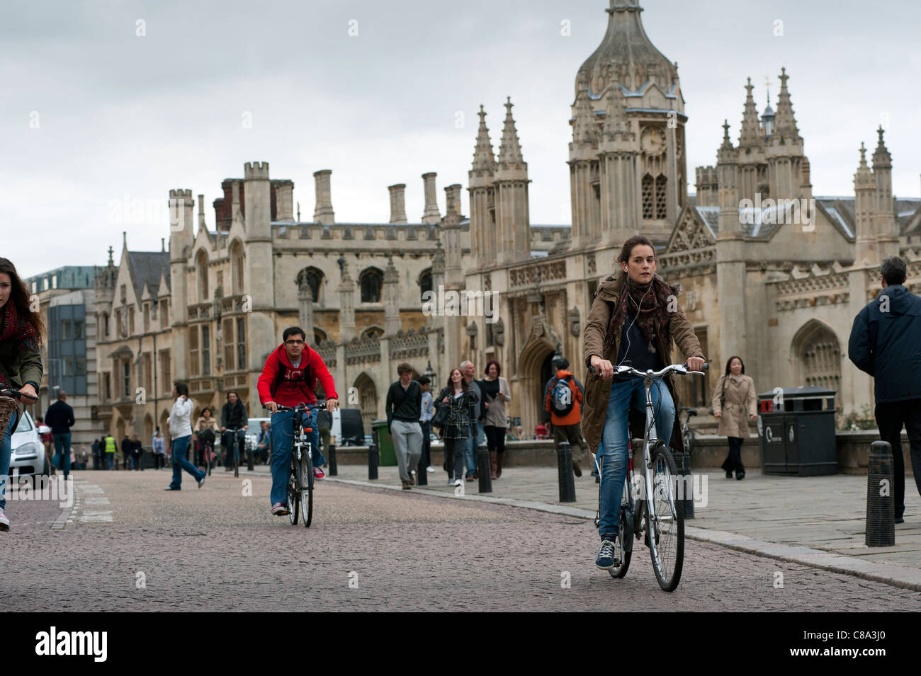 Cambridge University, England. Students cycle past Kings College autumn ...