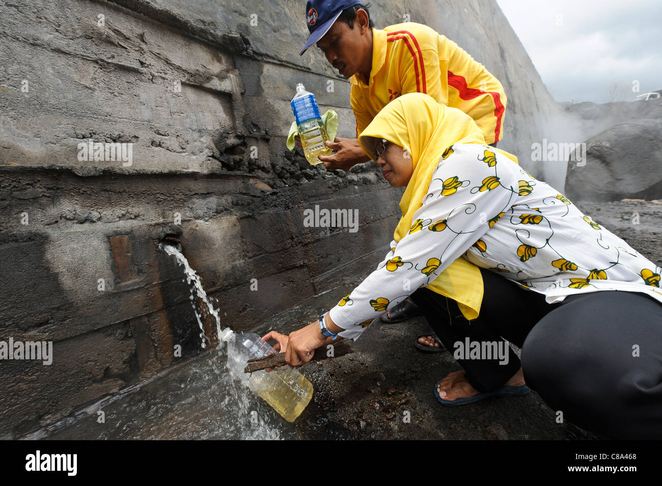 Locals collecting hot mineral water, Gendol River, Kaliadem, nr ...