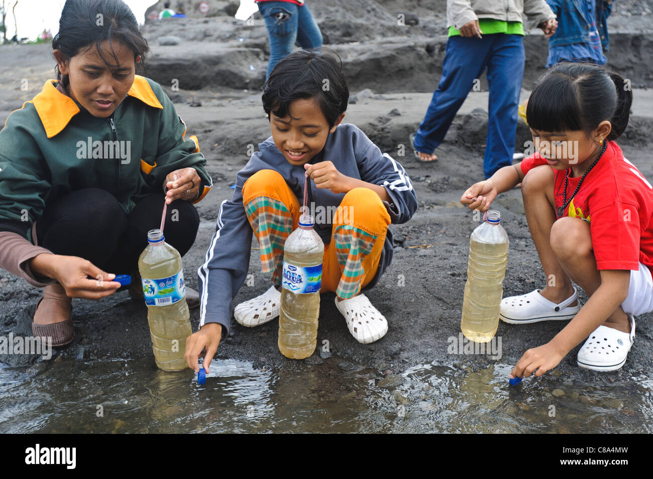 Family at the Gendol River which flows through the remains of a ...