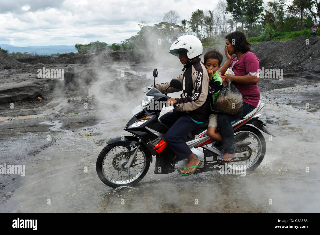 Family crossing the Gendol river which flows through the remains of a ...