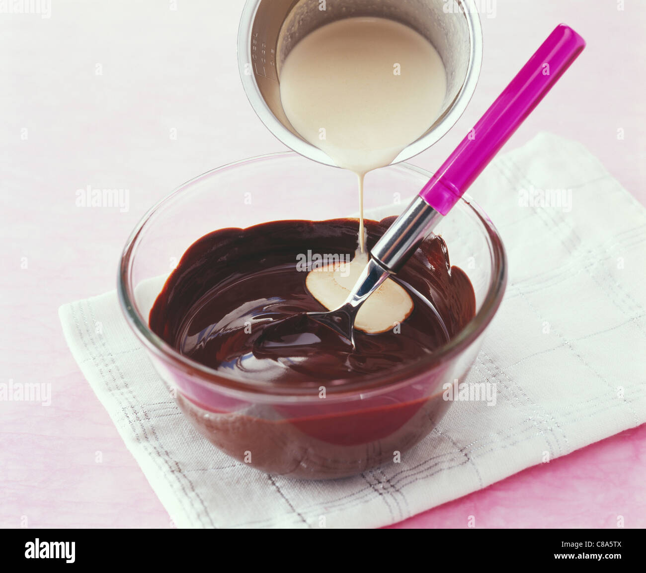Adding the custard to the melted chocolate Stock Photo - Alamy