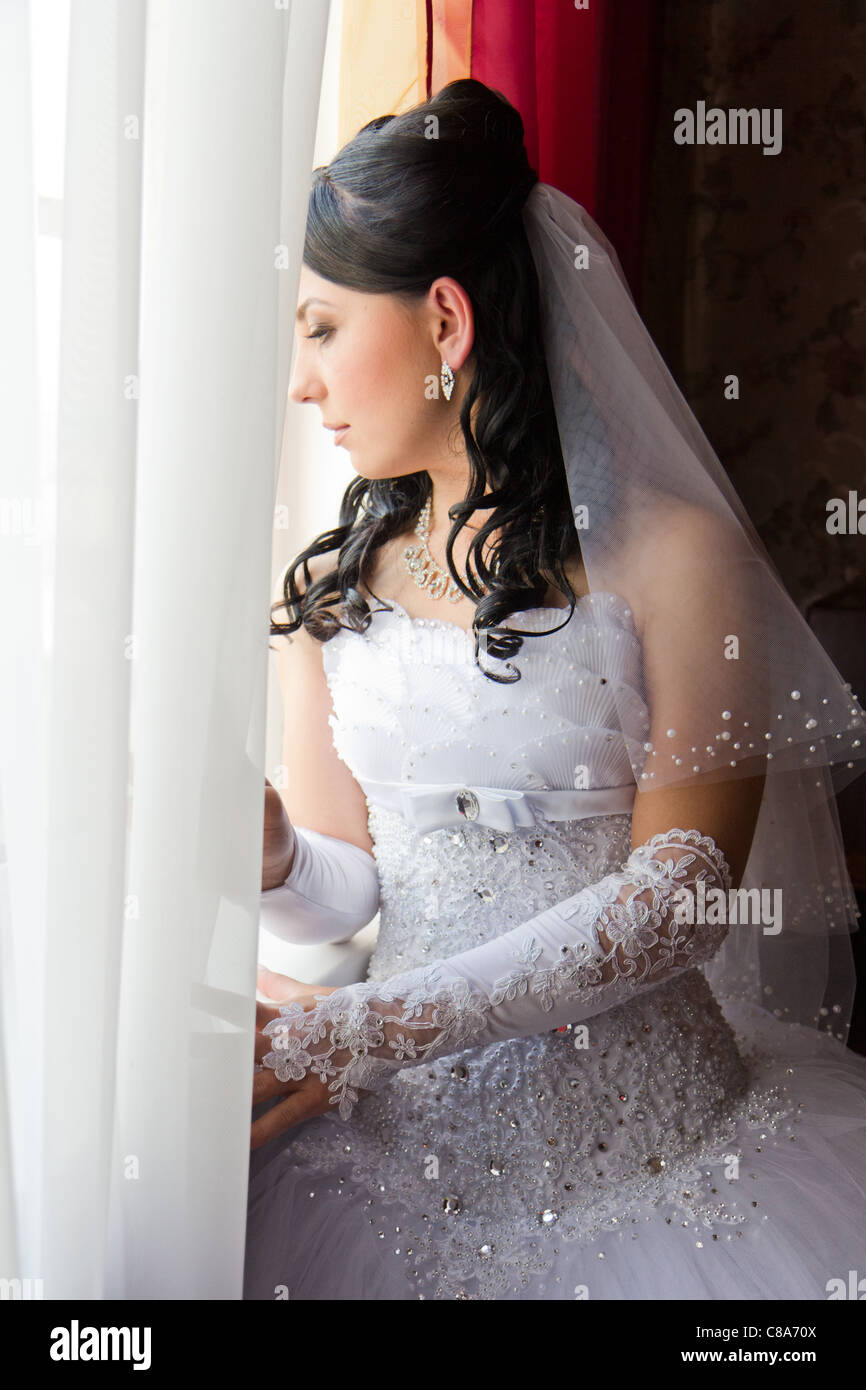 Beautiful bride looking out of the window Stock Photo - Alamy