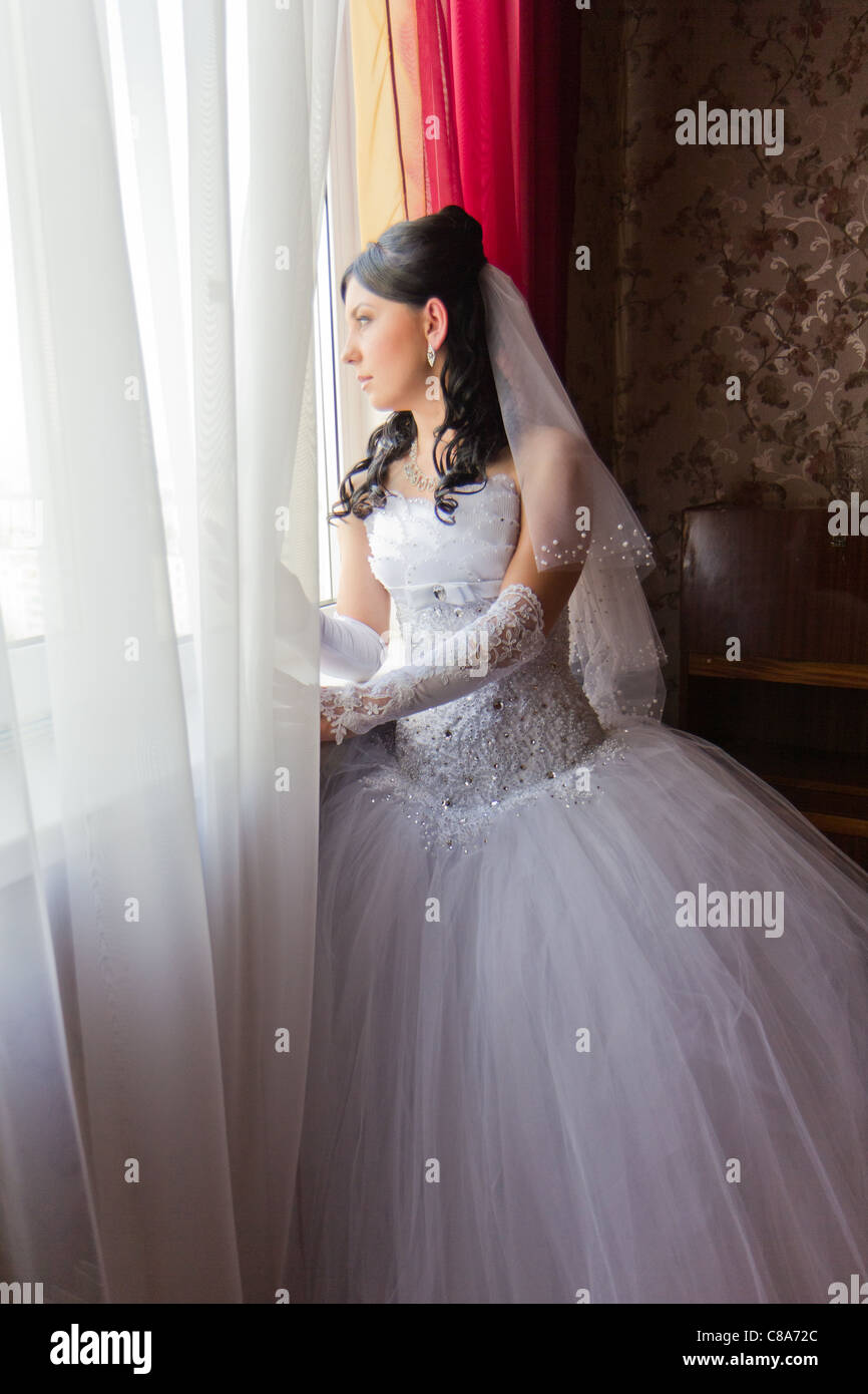 Beautiful bride looking out of the window Stock Photo - Alamy