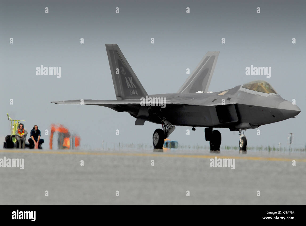 Airmen watch as an F-22 Raptor taxis toward a refueling station March ...