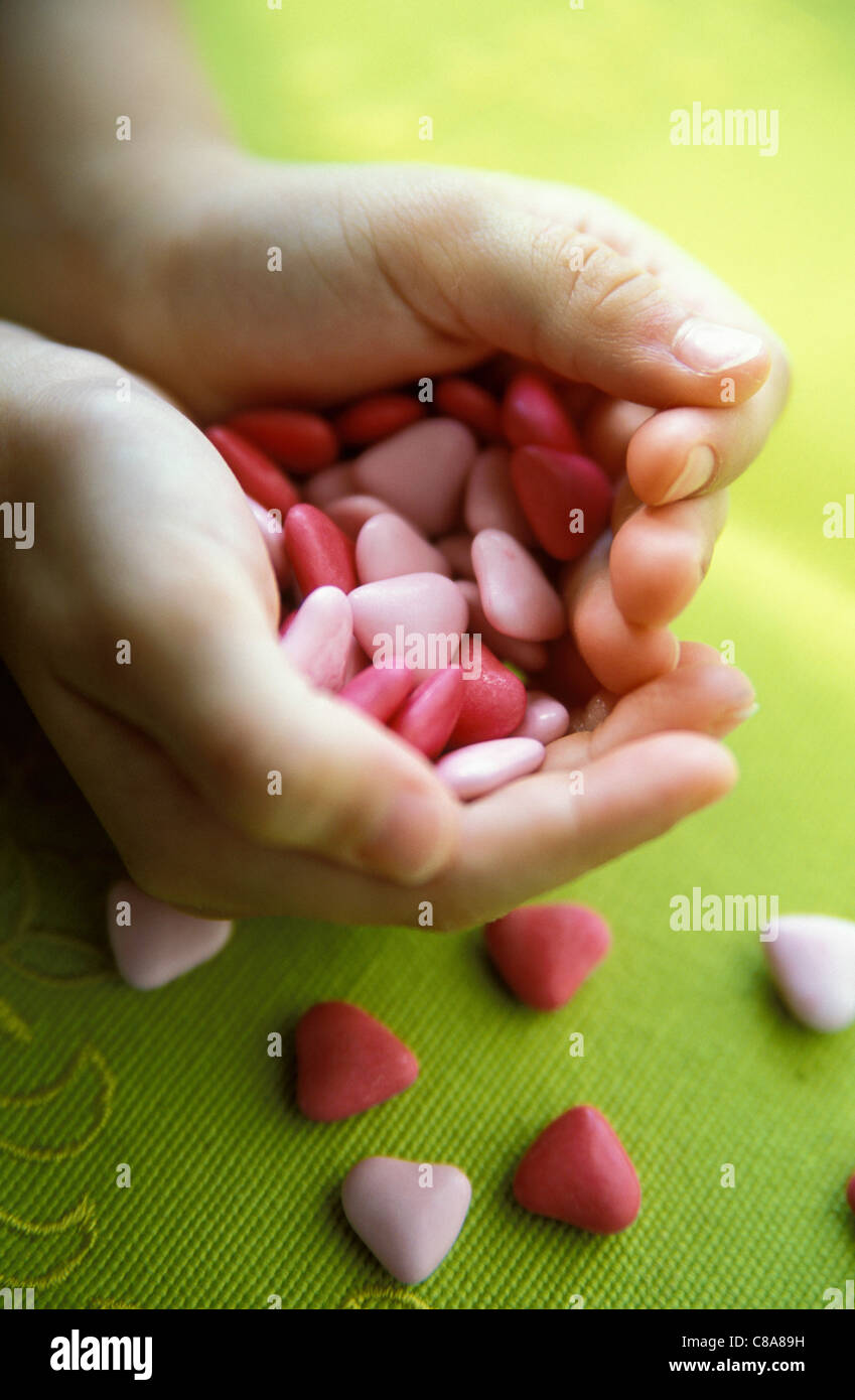 Child's hands holding heart-shaped sweets Stock Photo - Alamy