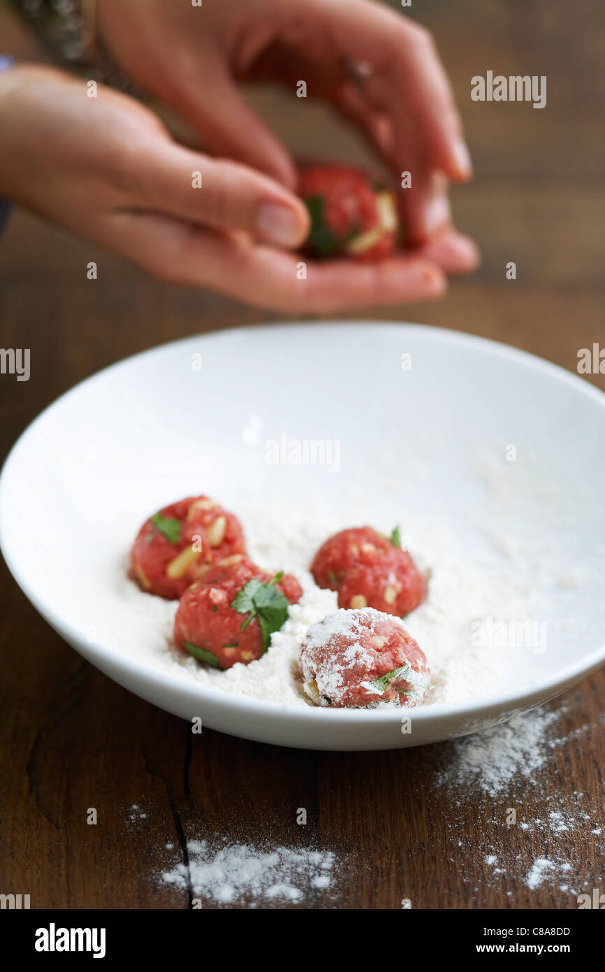 Rolling the meatballs in the flour Stock Photo - Alamy