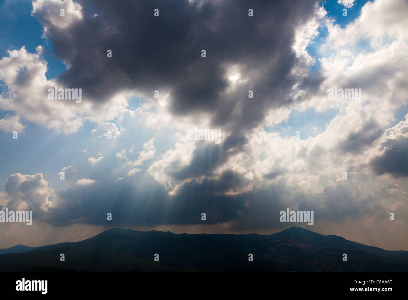 Broken rain clouds with blue sky and sun streaming through clouds and ...