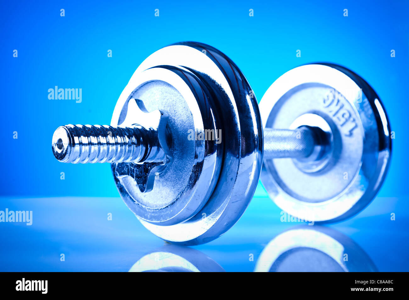 fitness dumbbells on the blue background Stock Photo - Alamy