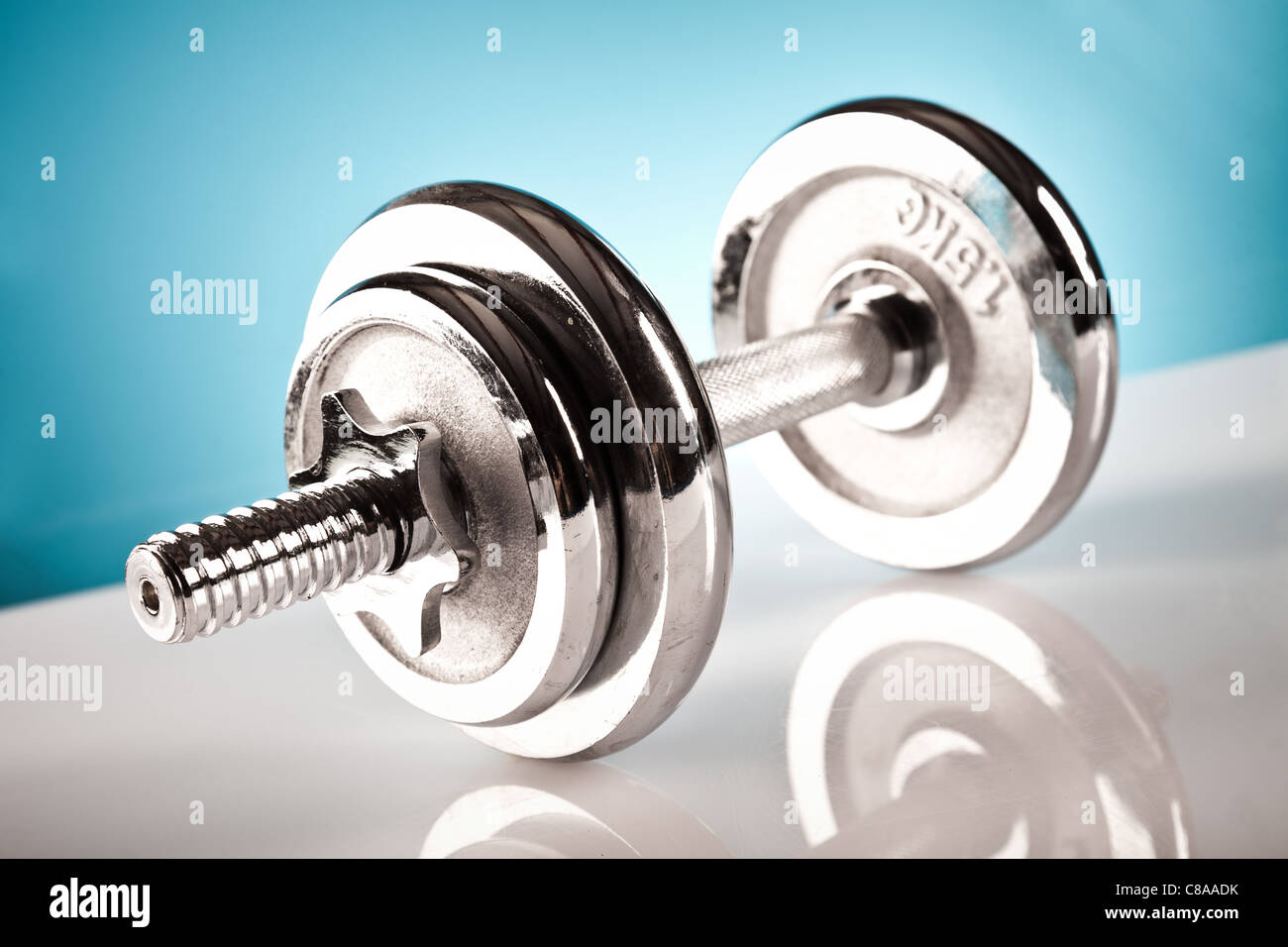 fitness dumbbells on the blue background Stock Photo - Alamy