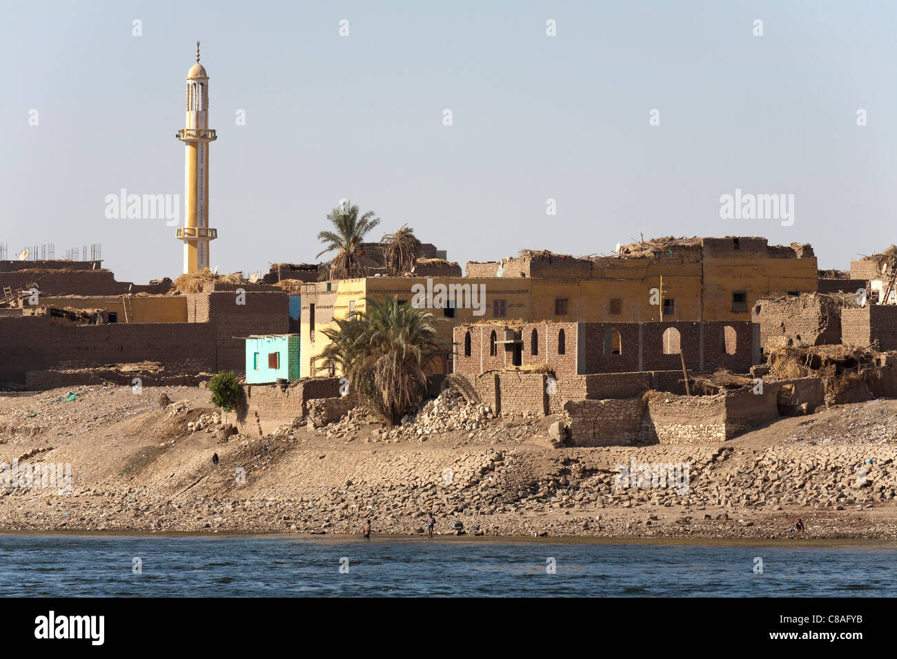 Section of Nile river bank with traditional rambling houses, one under ...