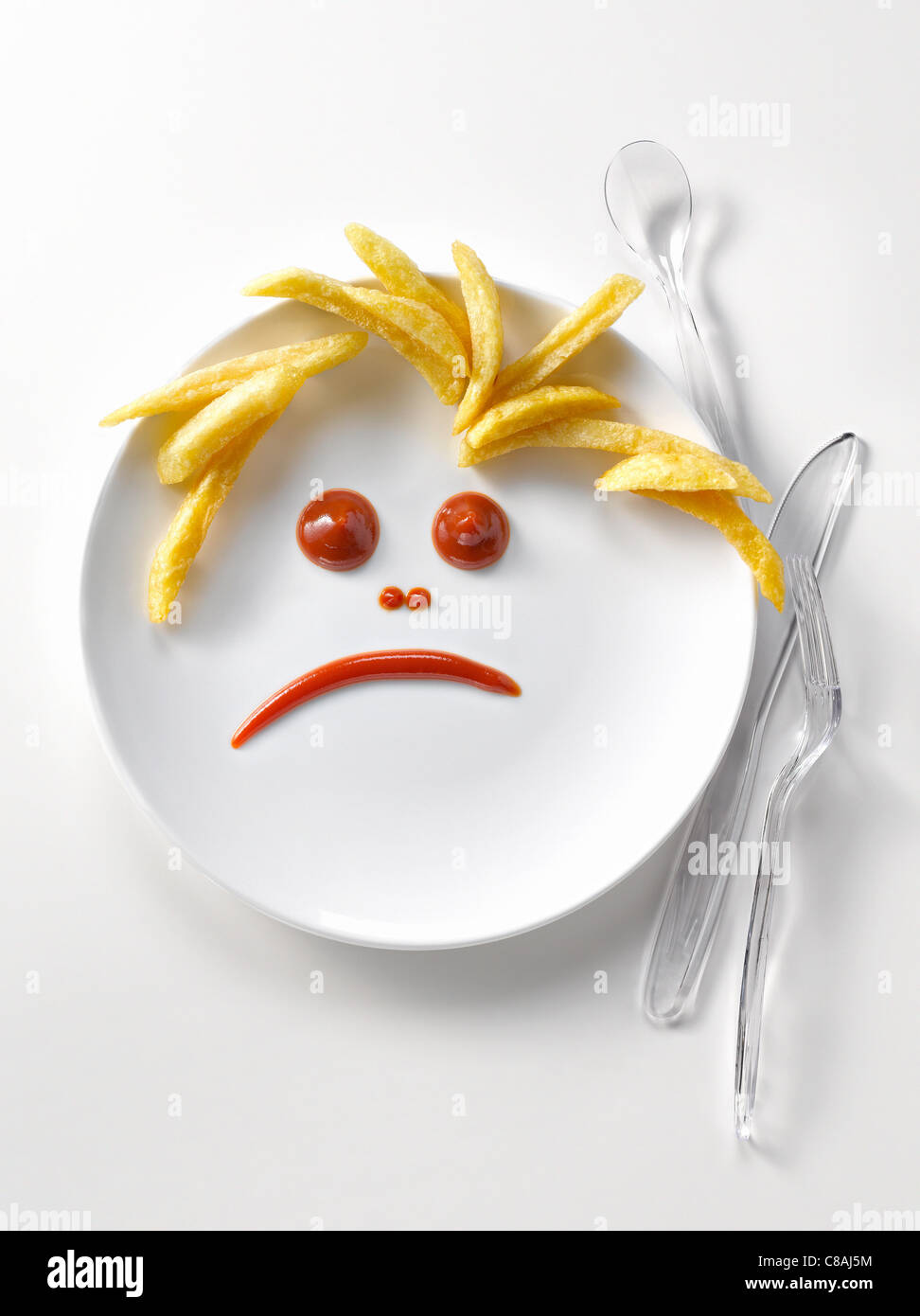 Plate of french fries and ketchup in the shape of a sad face Stock ...