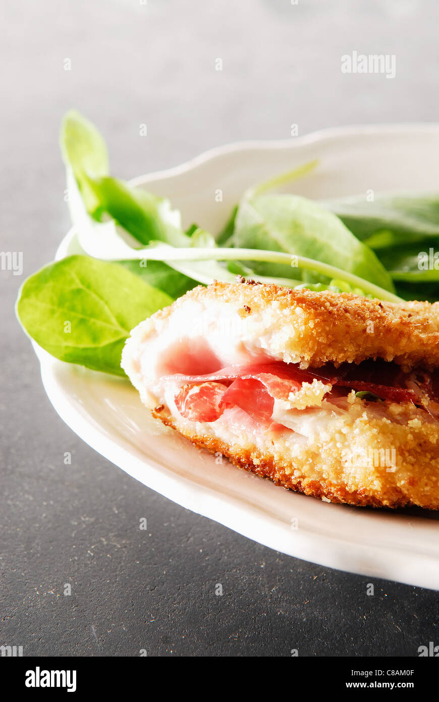 Breaded escalope with mozzarella and raw ham,spinach and rocket salad ...