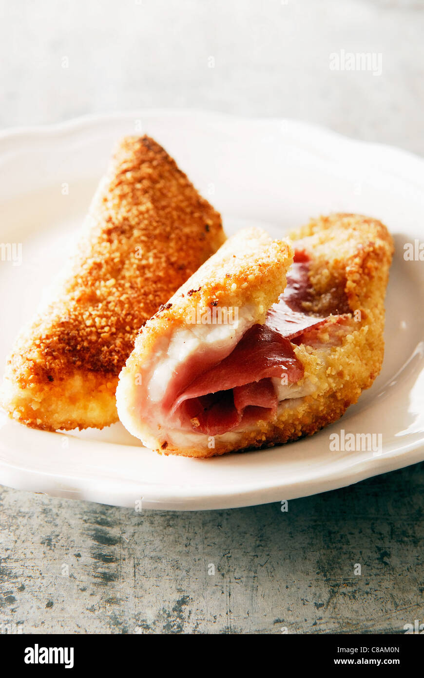 Breaded escalope with mozzarella and raw ham Stock Photo - Alamy