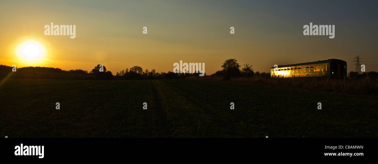 An East Midlands Train catches the setting sun's glint, Willington ...